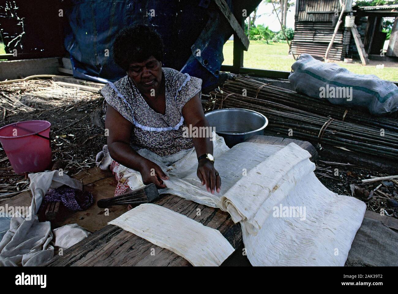 A local woman produces tapa cloth from bark on the island of Vatulele ...