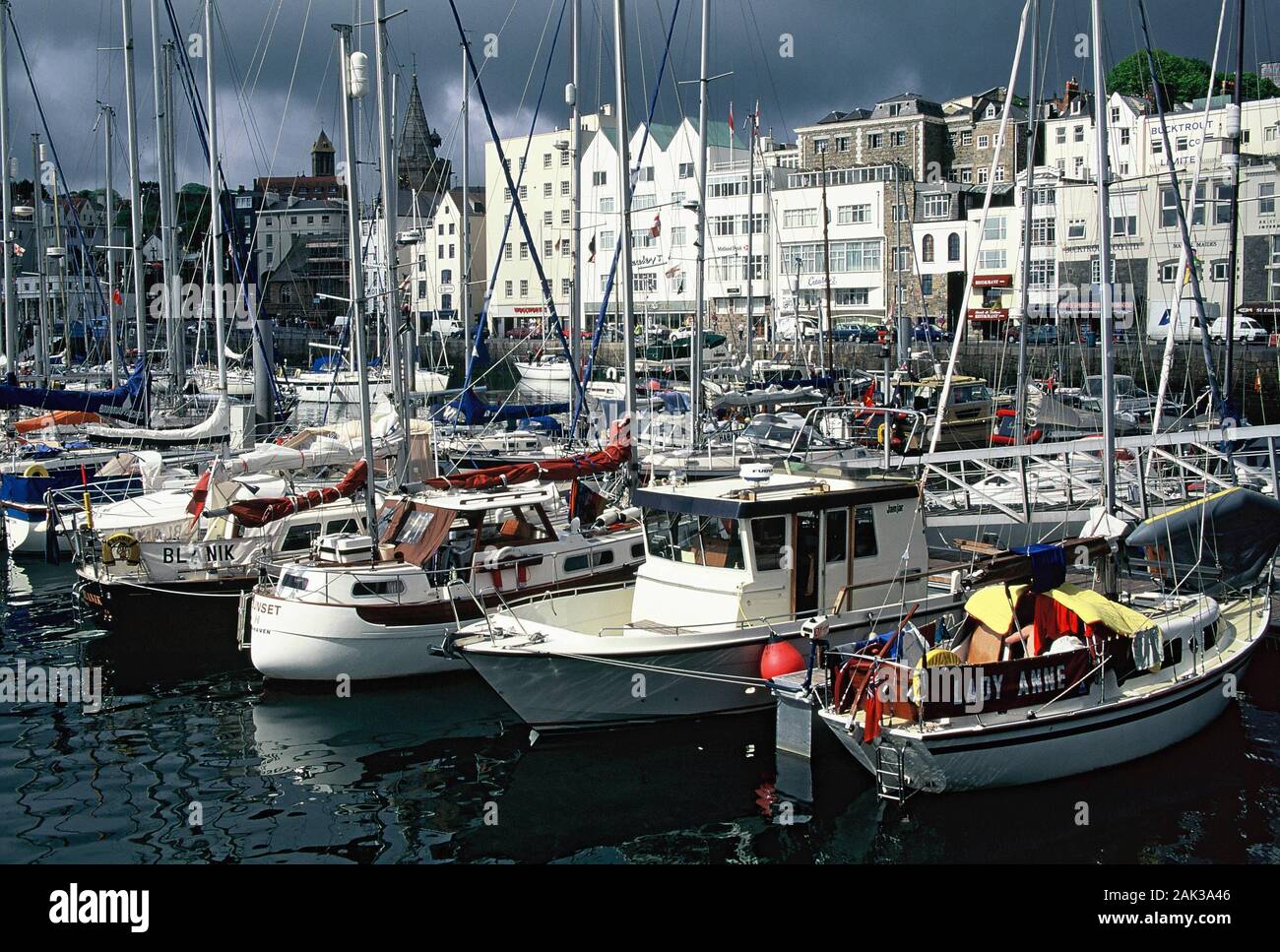 Sailing boats anchoring in the harbor of St. Peter Port on the island ...