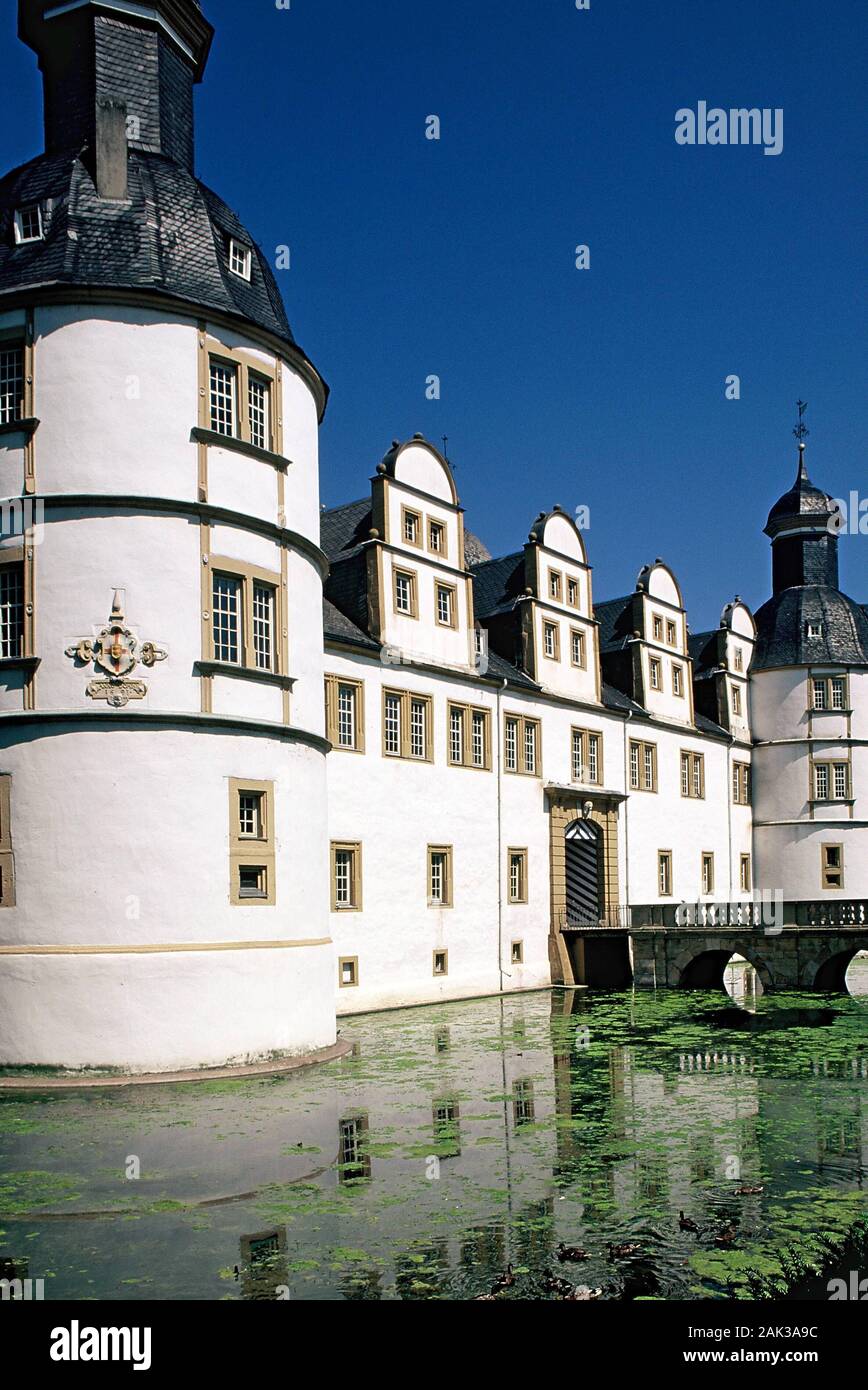 The white facade of Neuhaus Castle in Paderborn reflects in the moat ...