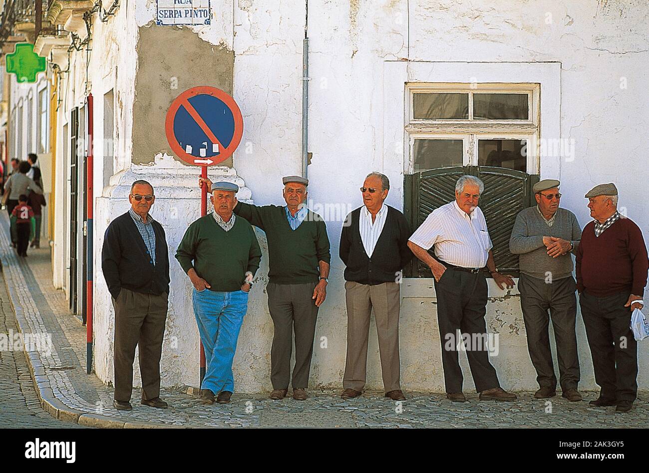 A group of men who are in a conversation with each other in a street in ...