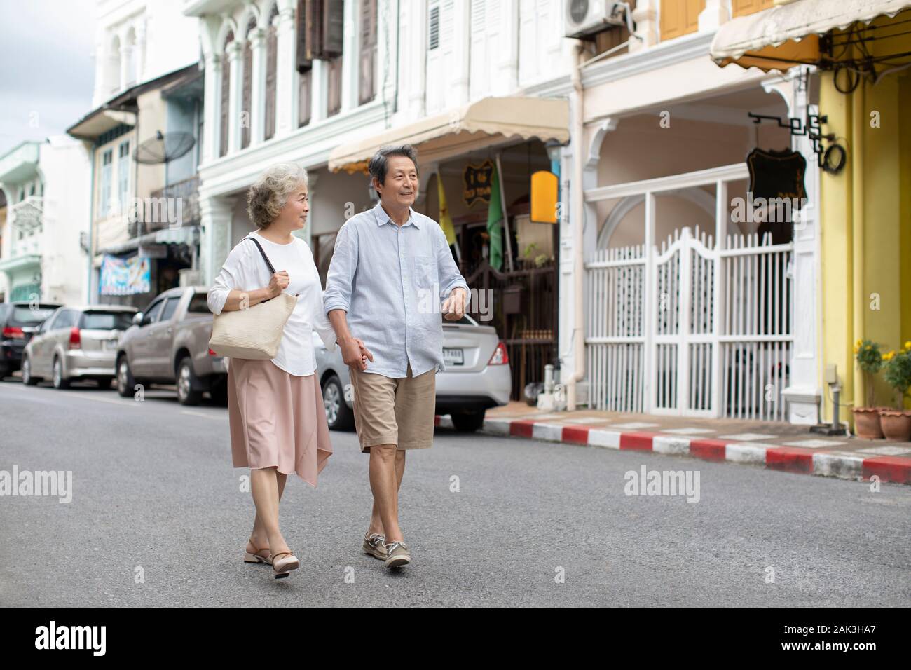 Happy senior Chinese couple walking on street Stock Photo - Alamy