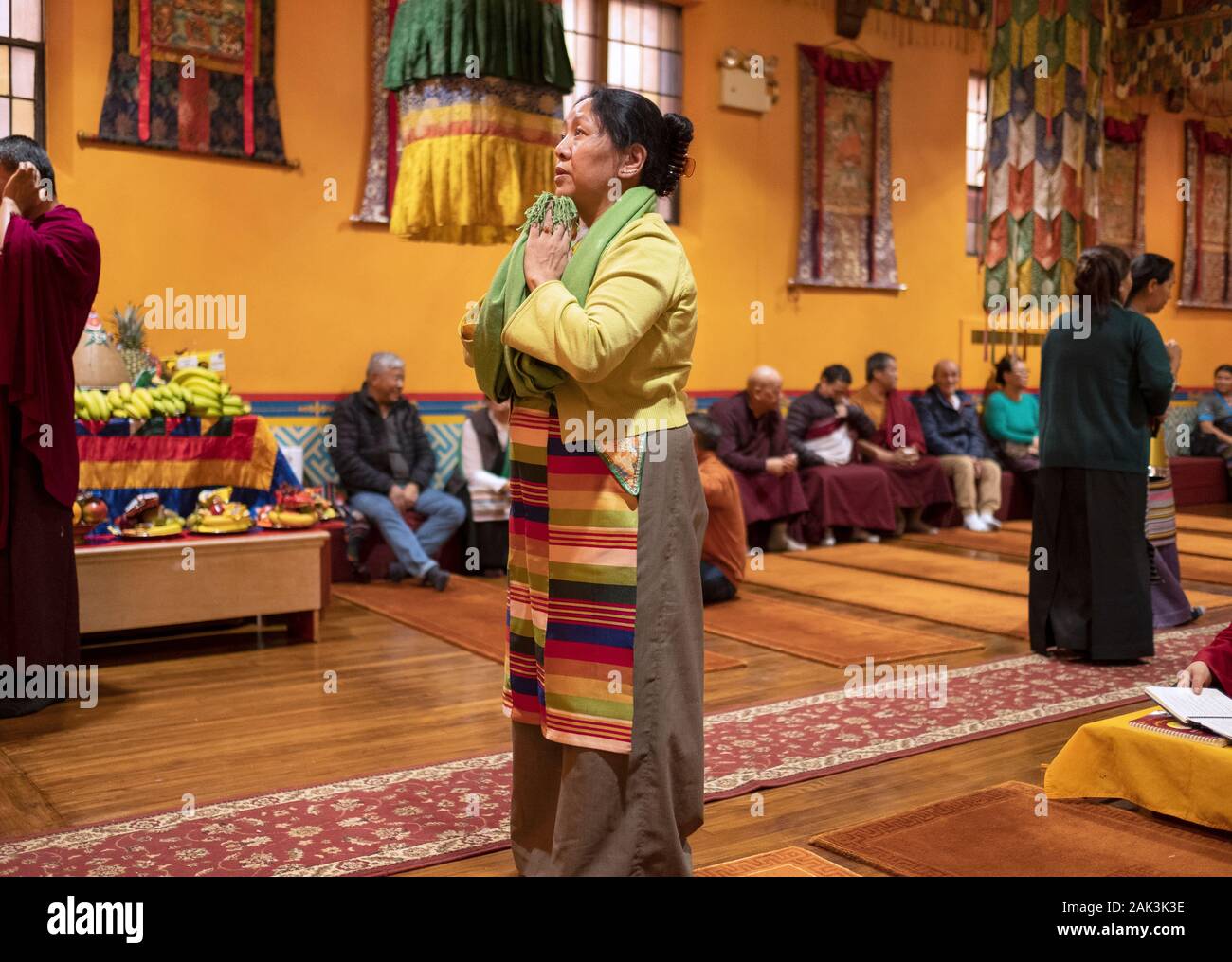 A devout Buddhist woman praying and meditating as she enters a temple ...