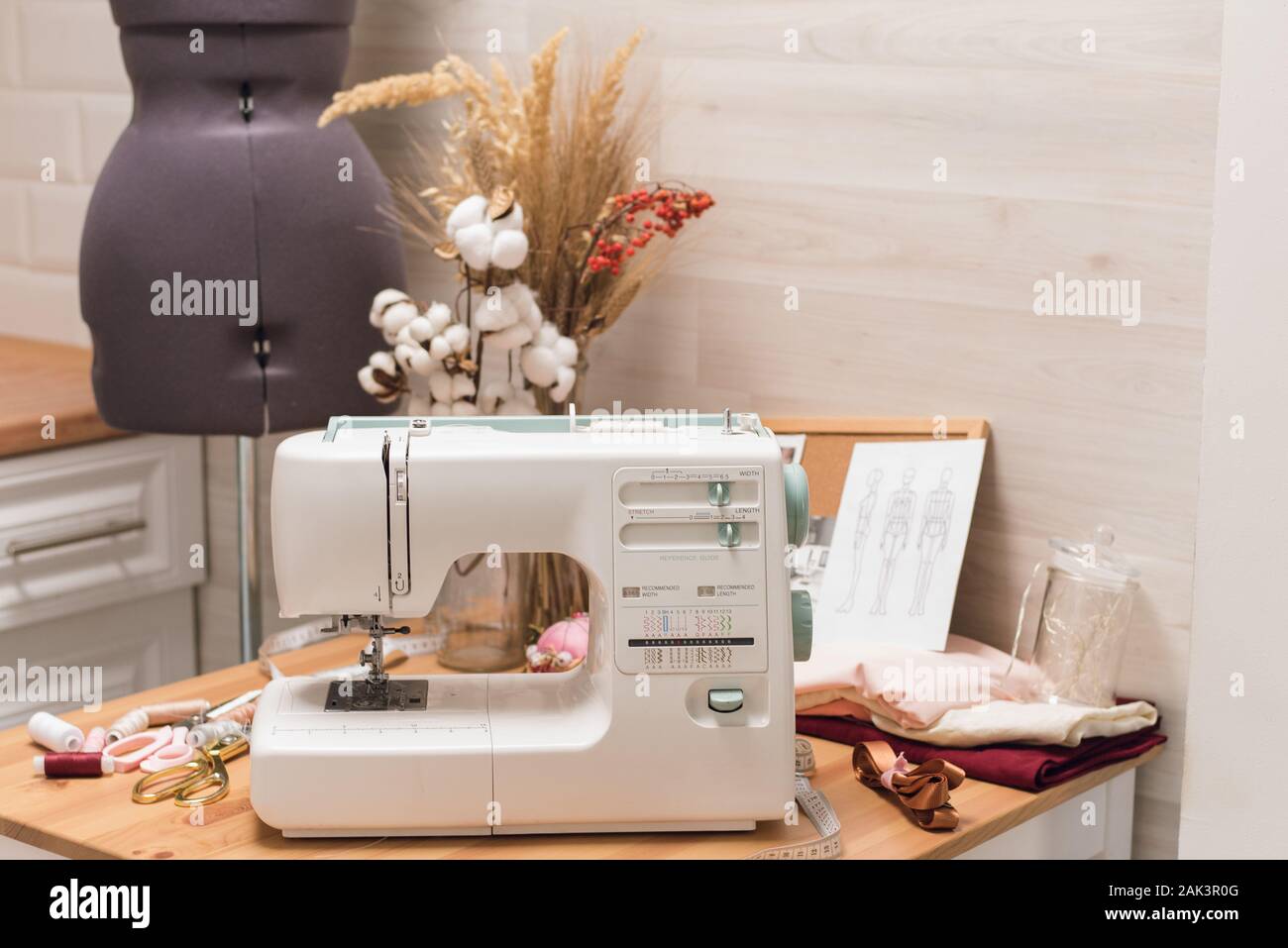 The workplace of a seamstress. Sewing machine on the table, thread ...