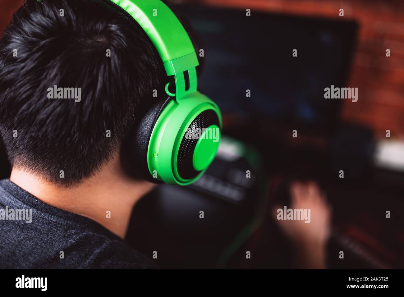 Back view of gamer in headphones playing video game Stock Photo - Alamy