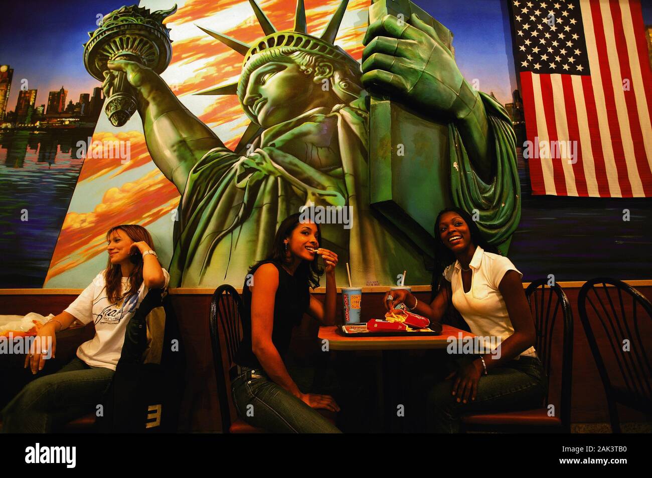 Two young women sit in a fast food restaurant in Manhatten New York in ...