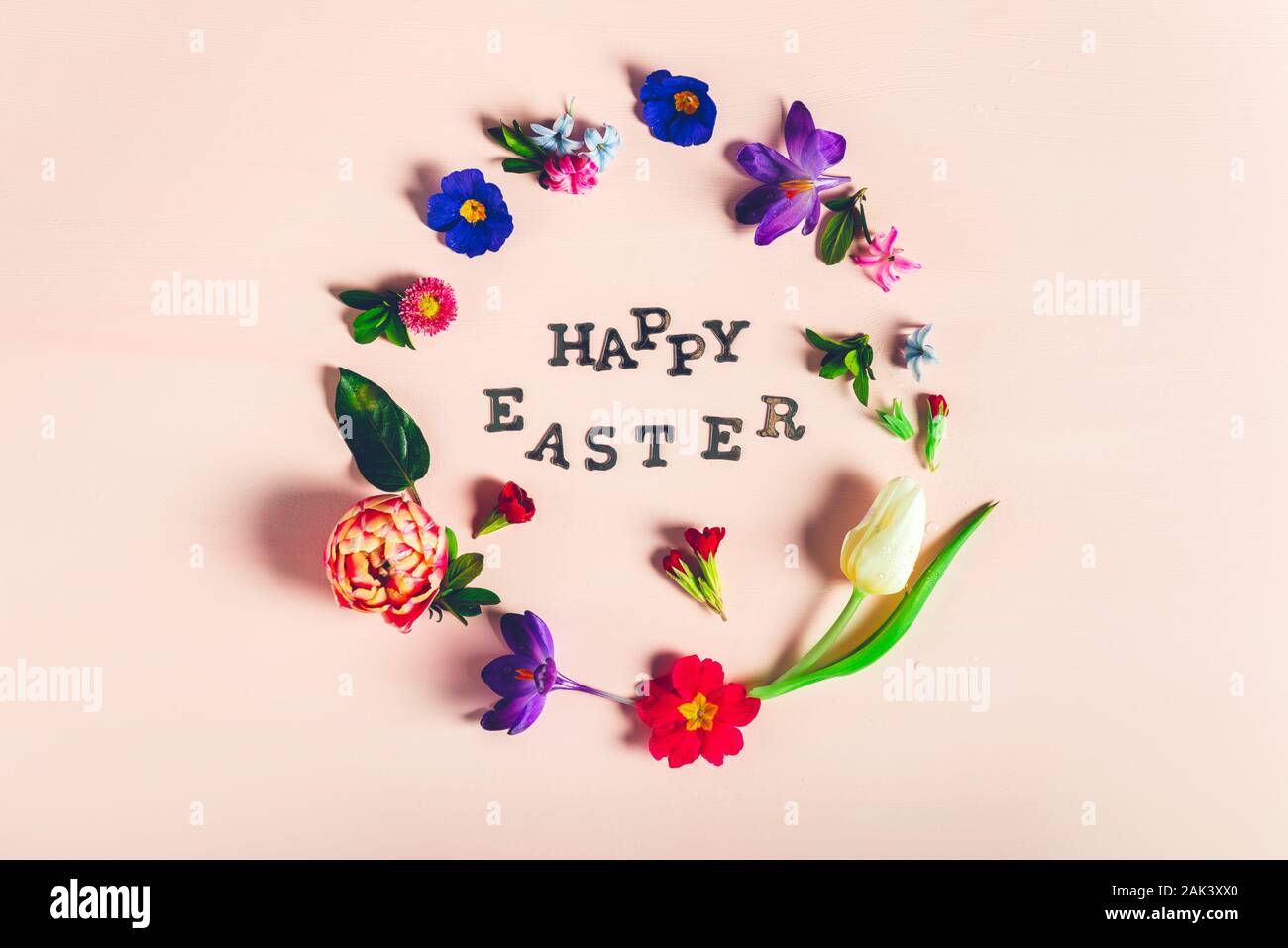 Happy Easter letters with different spring flowers around them, flat ...