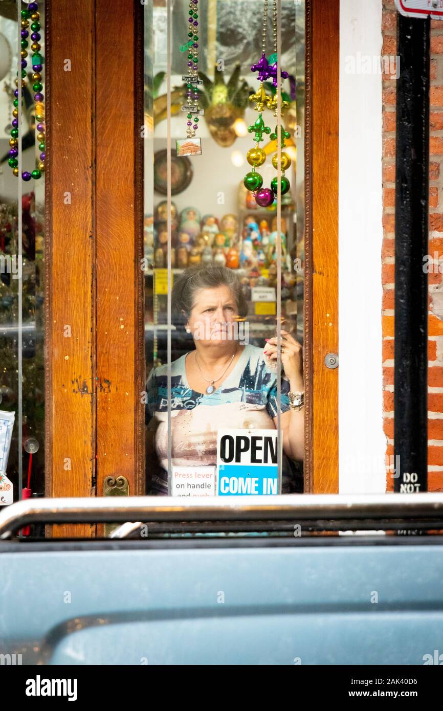 stern looking old woman shopkeeper looks out of craft shop window in ...