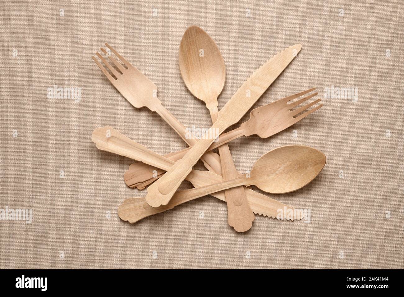 Two sets of natural wooden handcrafted cutlery arranged as a flat lay ...