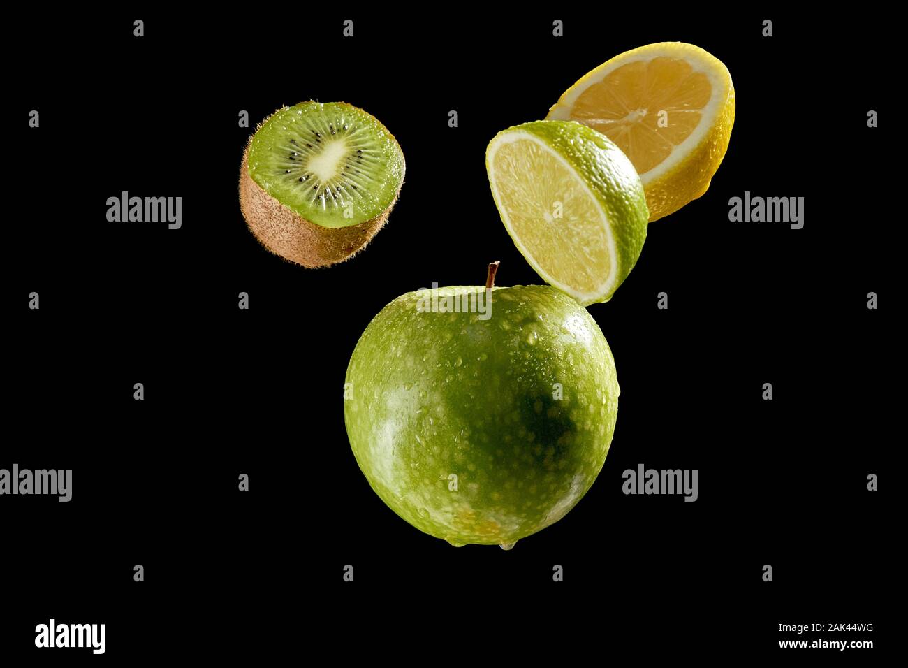 Green fresh fruits halves on black background Stock Photo - Alamy