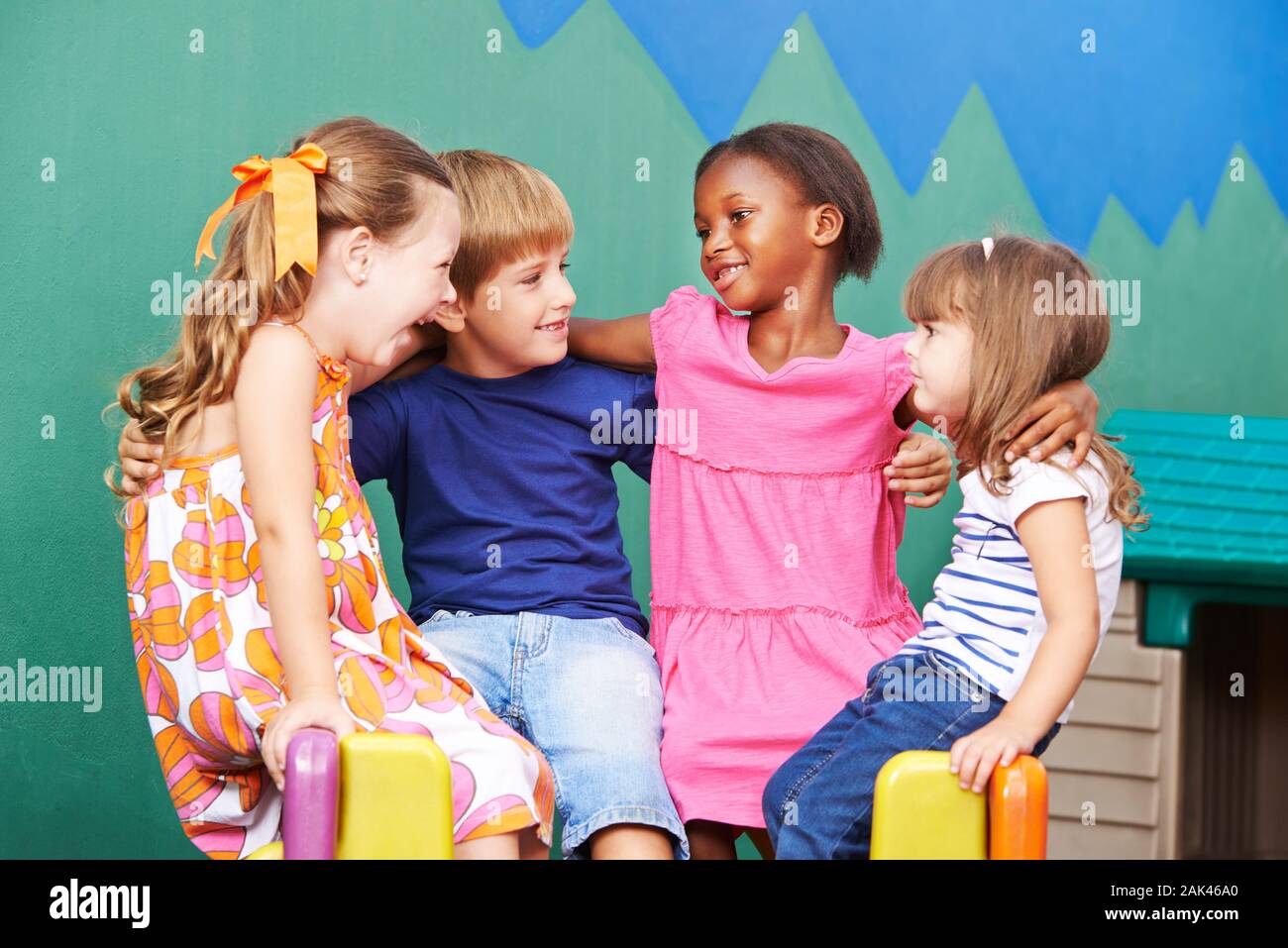 Happy group of kids hugs out of friendship in kindergarten Stock Photo ...