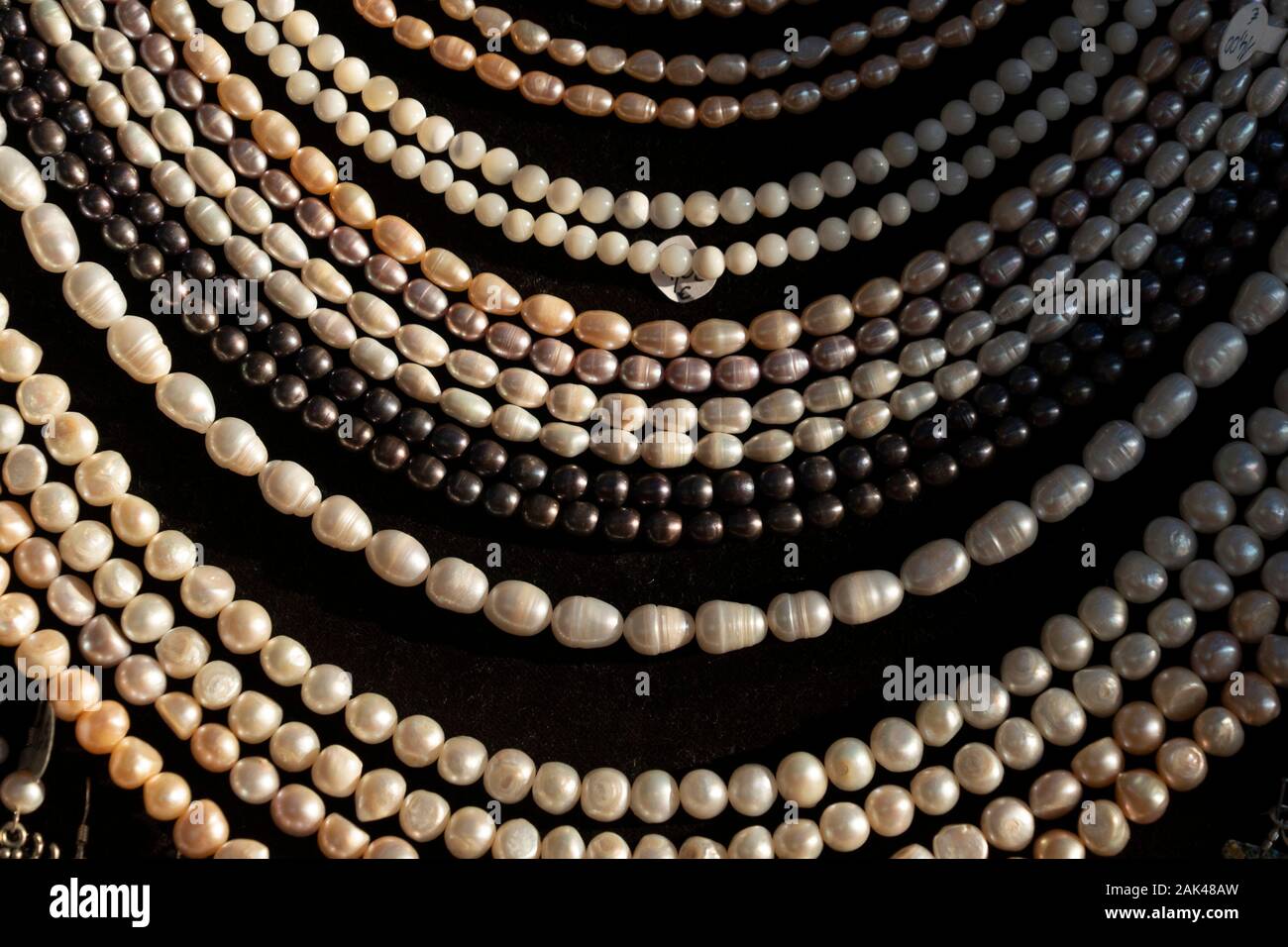 Pearl necklage earrings jewelry on display stand in a shop market ...