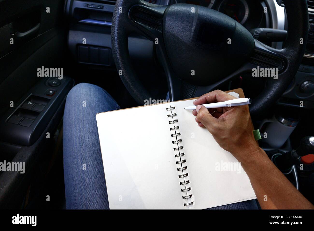 Photo of a Photo of a hand writing with a pen on a notebook while ...