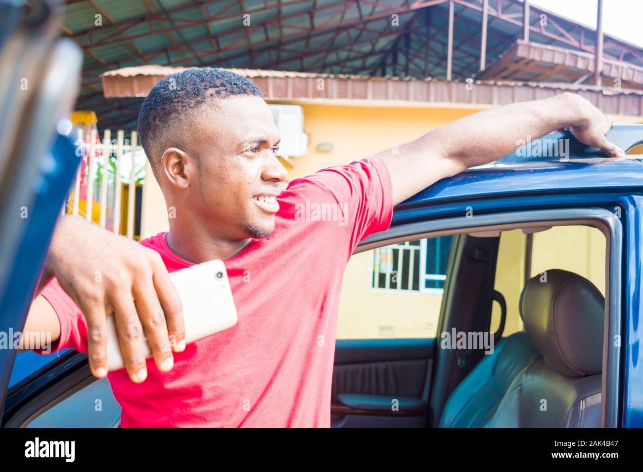 young handsome Nigerian taxi driver Waiting for passengers while ...