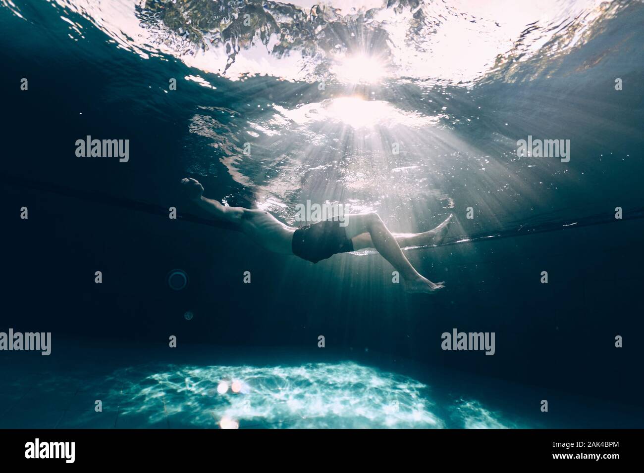 Underwater view on young man floating in swimming pool Stock Photo - Alamy