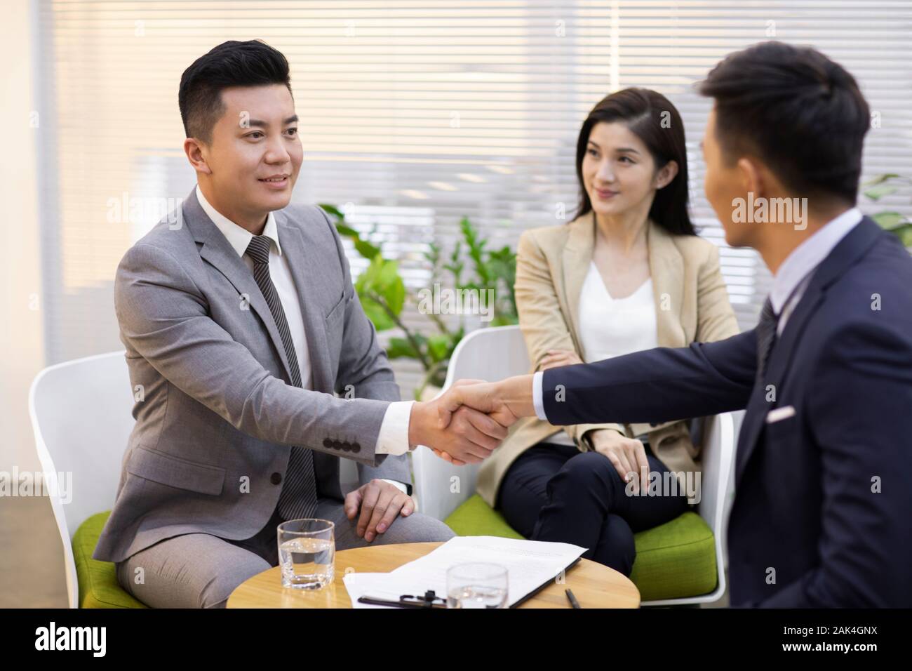 Chinese business people shaking hands in office Stock Photo - Alamy