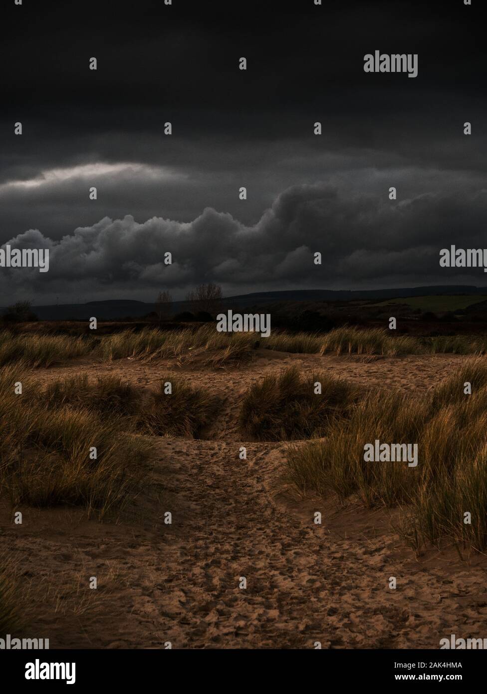 A dark brooding fantasy landscape. Grim, rain-filled storm clouds ...