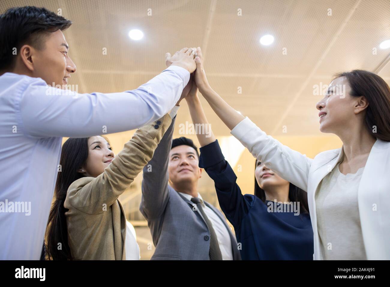 Chinese business people celebrating in office Stock Photo - Alamy
