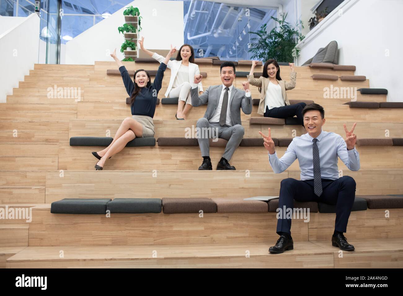 Chinese business people making victory sign in lecture hall Stock Photo ...