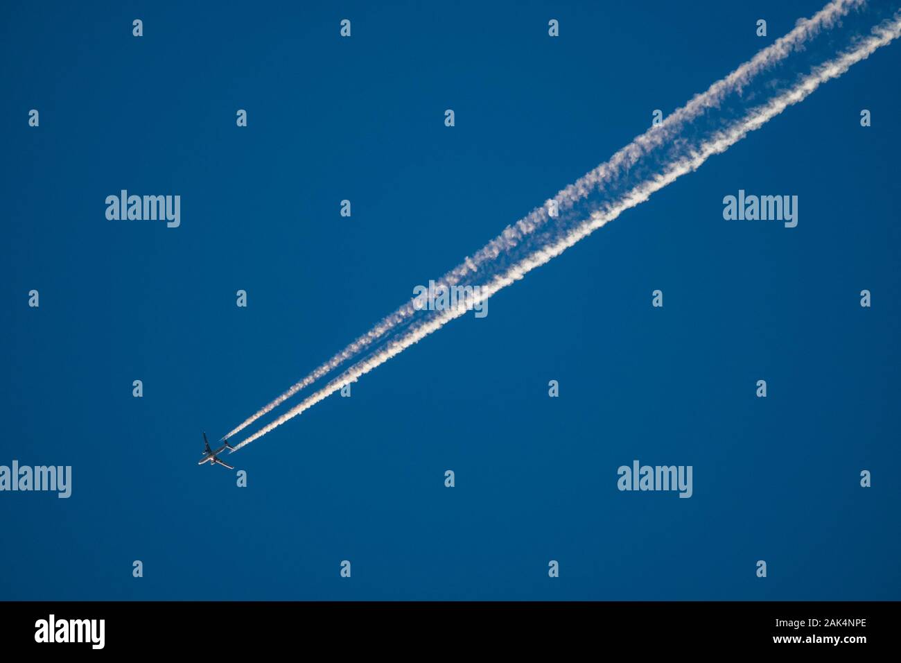 Bottom view of jet with trail and clear sky Stock Photo - Alamy