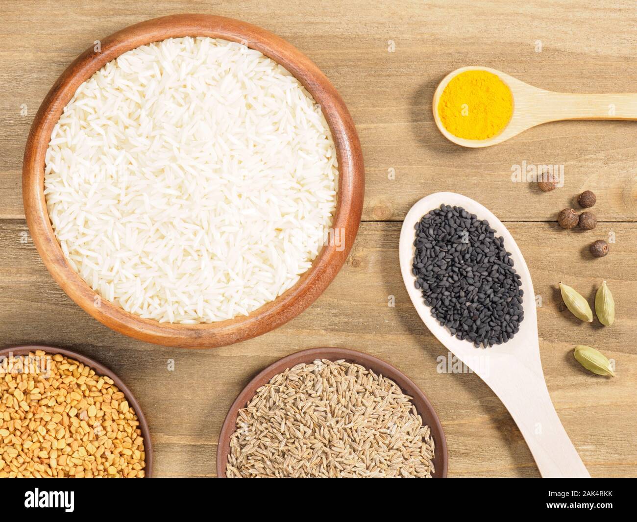 Rice, allspice, turmeric, green cardamom, cumin, fenugreek on brown ...