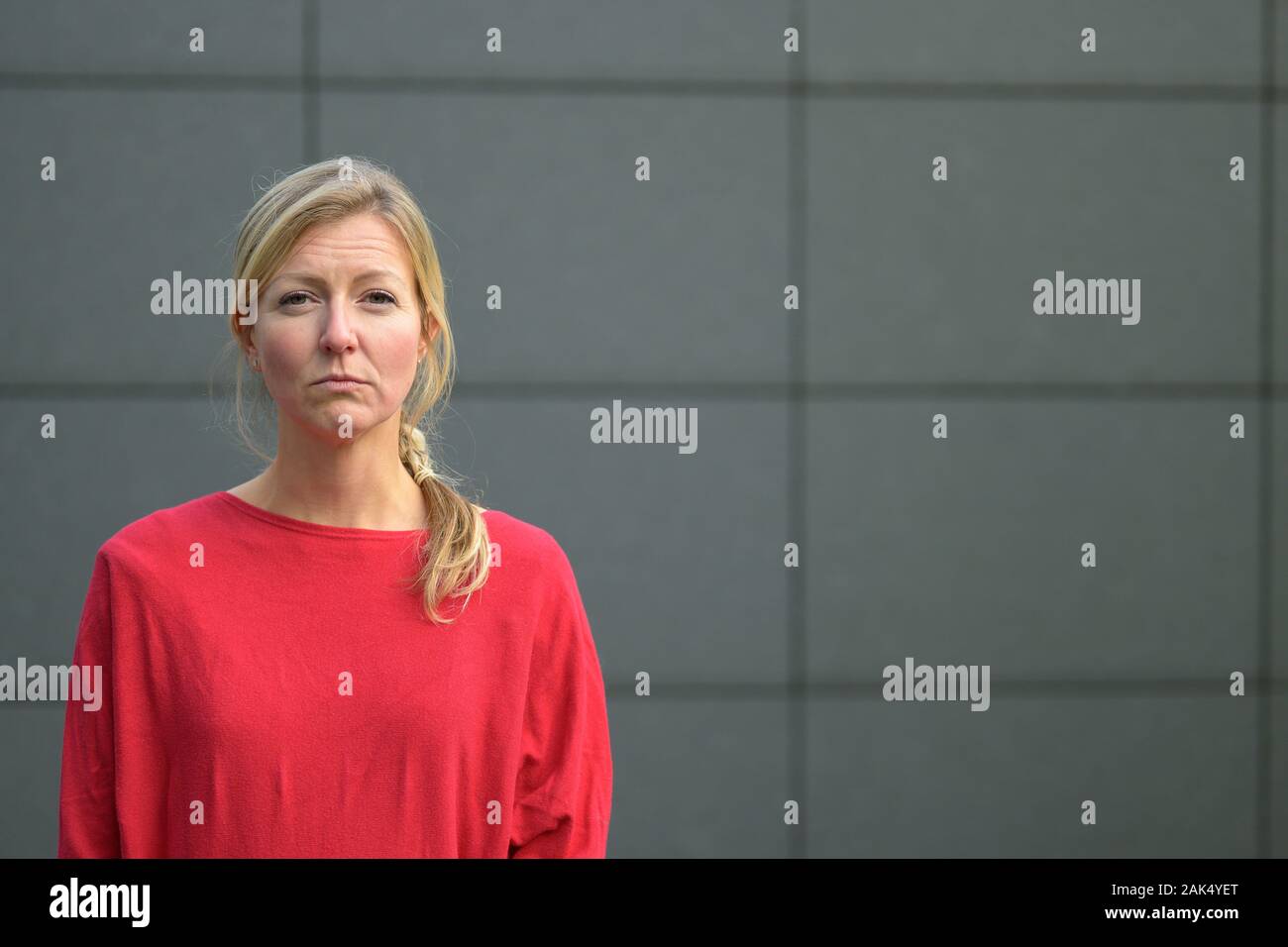 Vengeful woman slitting her eyes as she stares at the camera with a ...