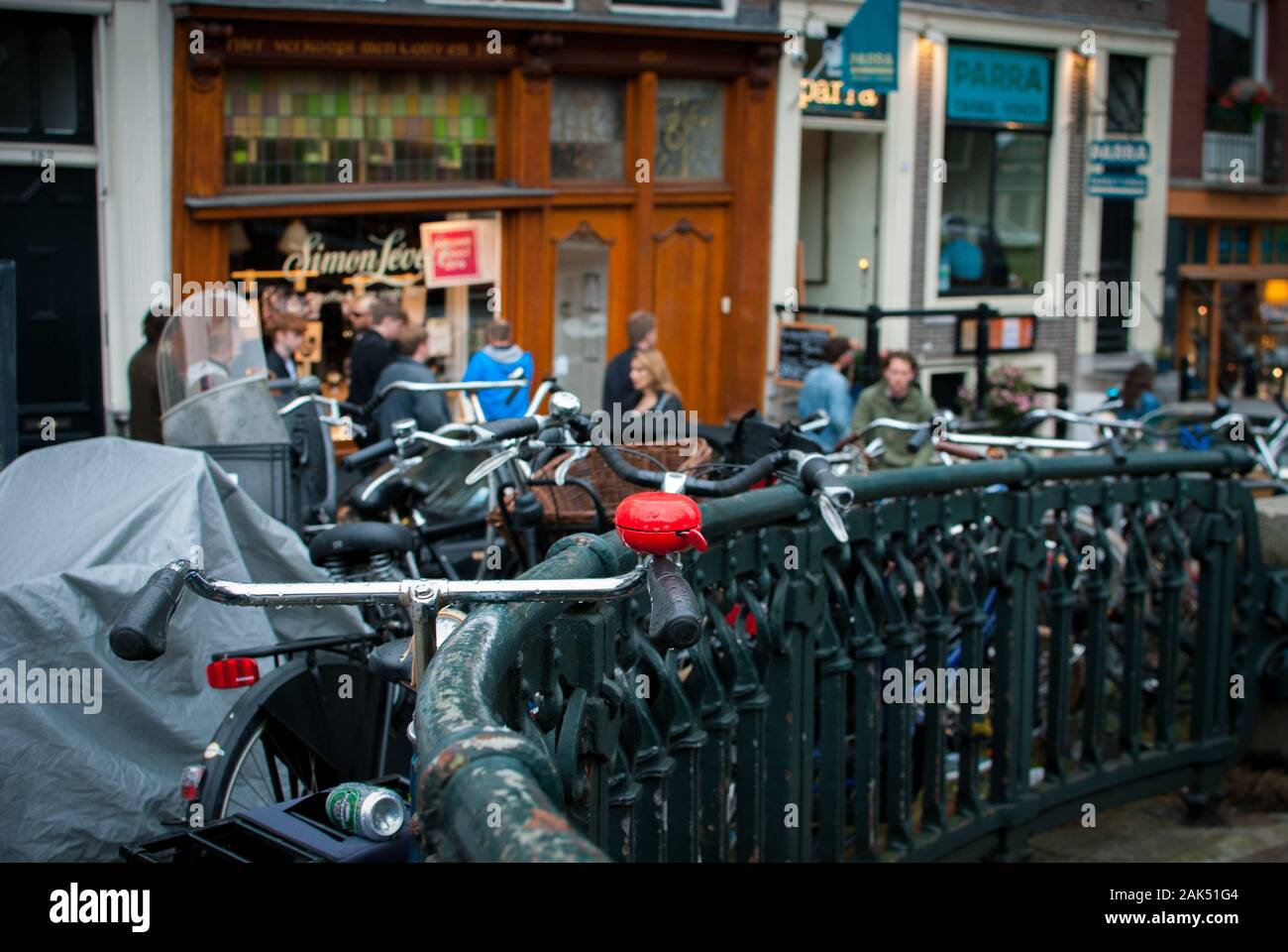 Parked bicycle along the bridge's green grid and on the back people ...