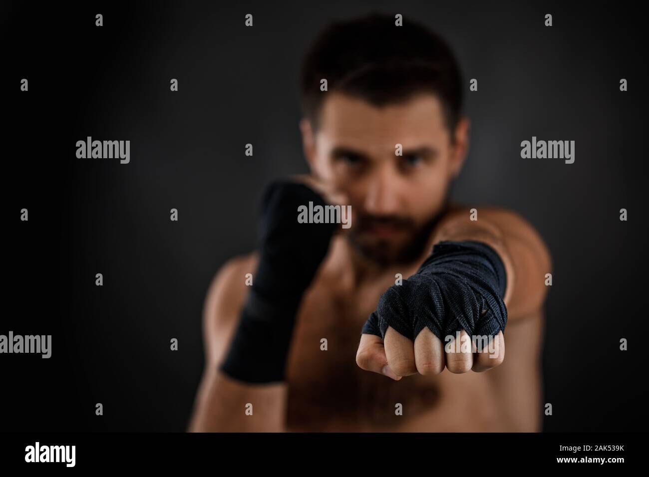 boxer man with bandage on hands training before fight and showing the ...