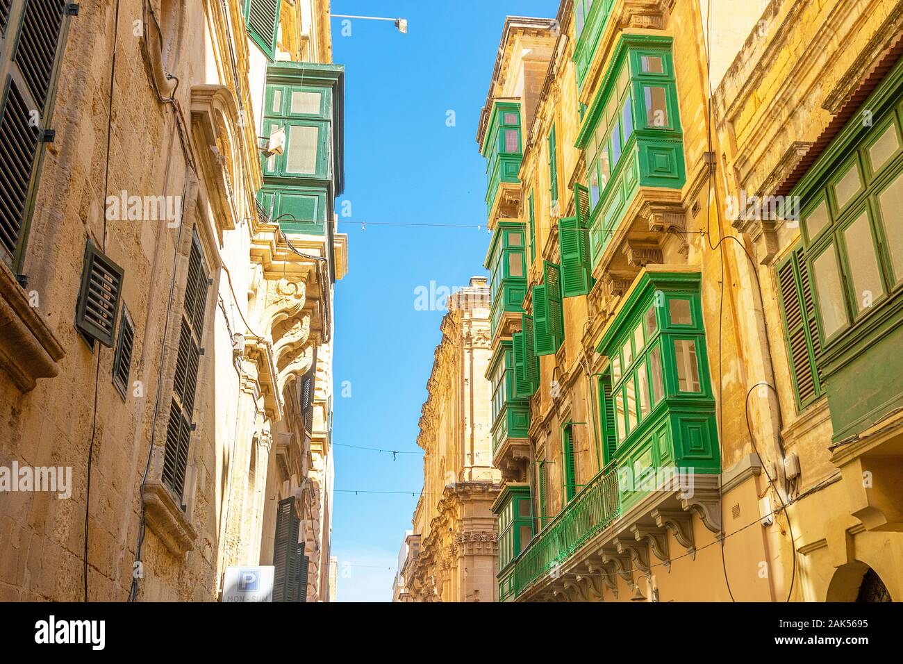 Typical narrow maltese streets with colorful traditional windows and ...