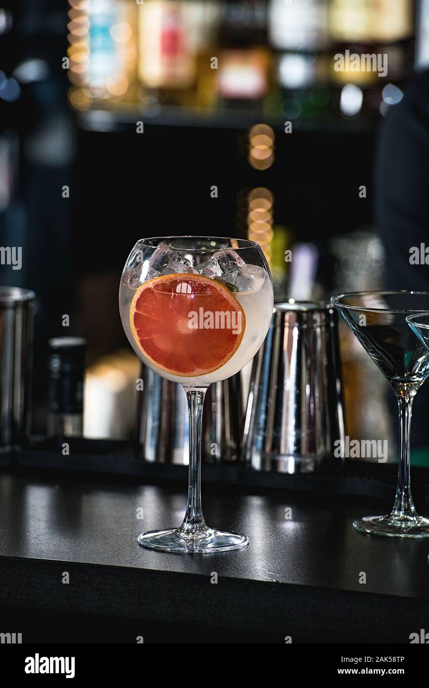 refreshing ruby red coctail with grape fruit isolated on a bar ...