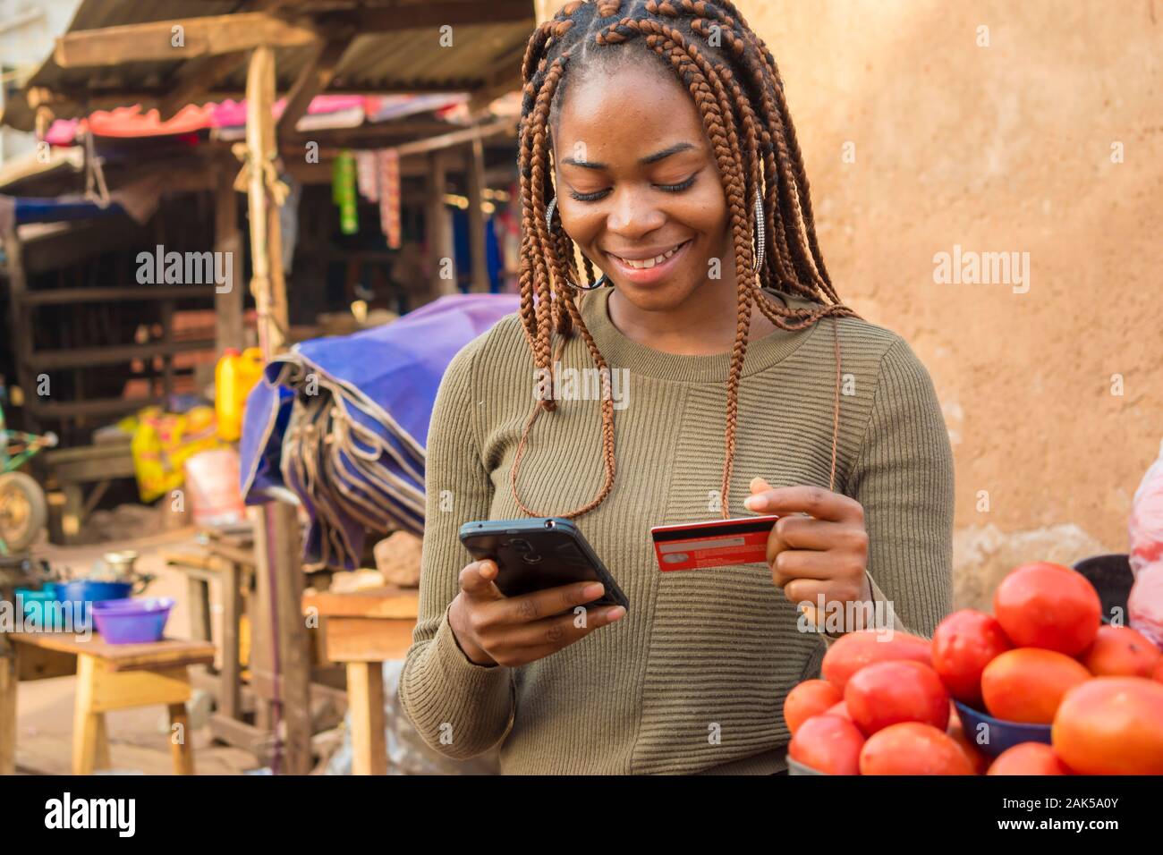 young black woman selling in a local african market using her mobile ...
