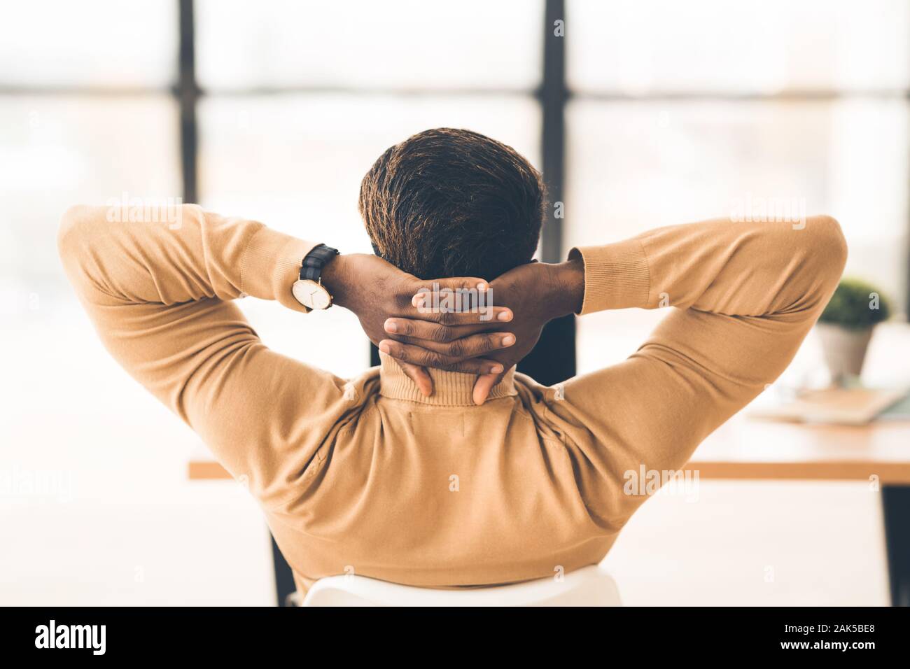 Relax In Office. Back view of black businessman having rest after ...