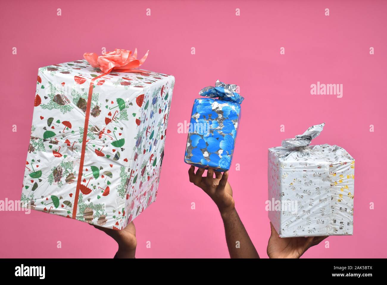 photo of people holding up gift boxes and present over their heads ...