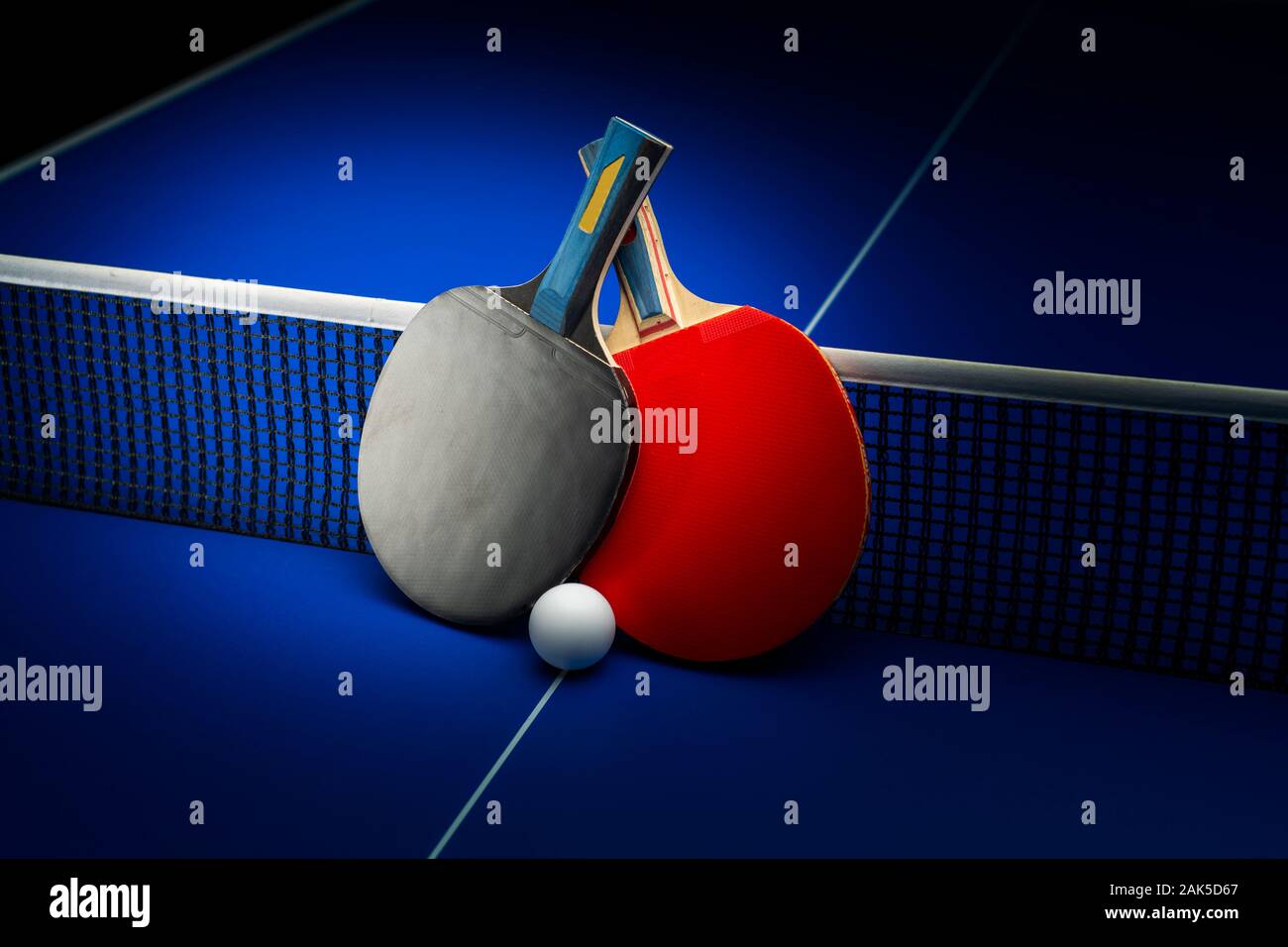 Two table tennis rackets and balls on a blue table with net Stock Photo ...