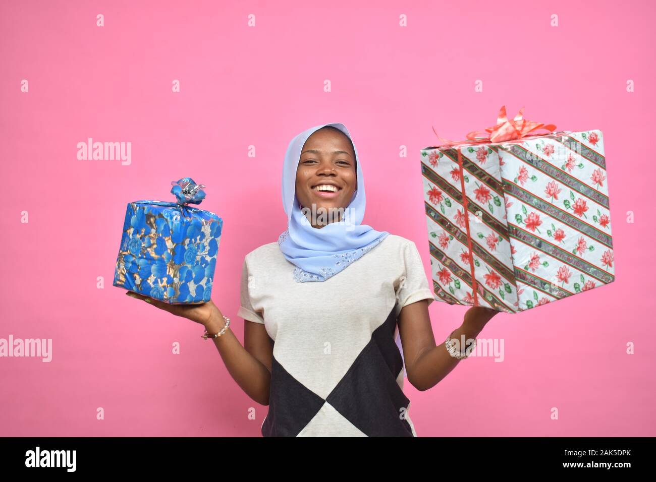 beautiful young african lady holding gift boxes smiling Stock Photo - Alamy
