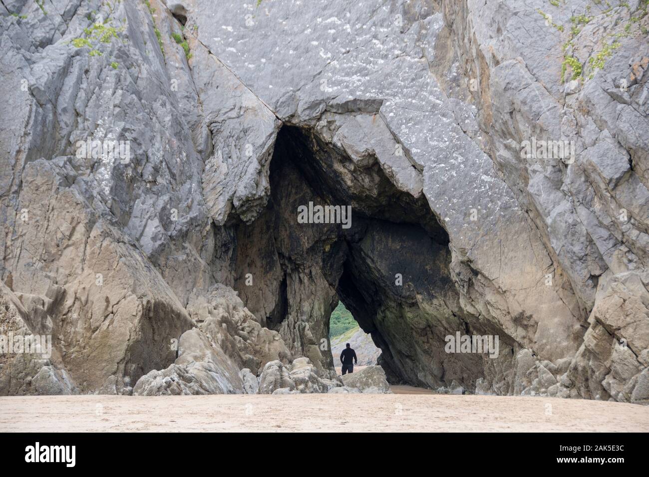 A close look at a craggy little cave opening in the cliff face at Three ...