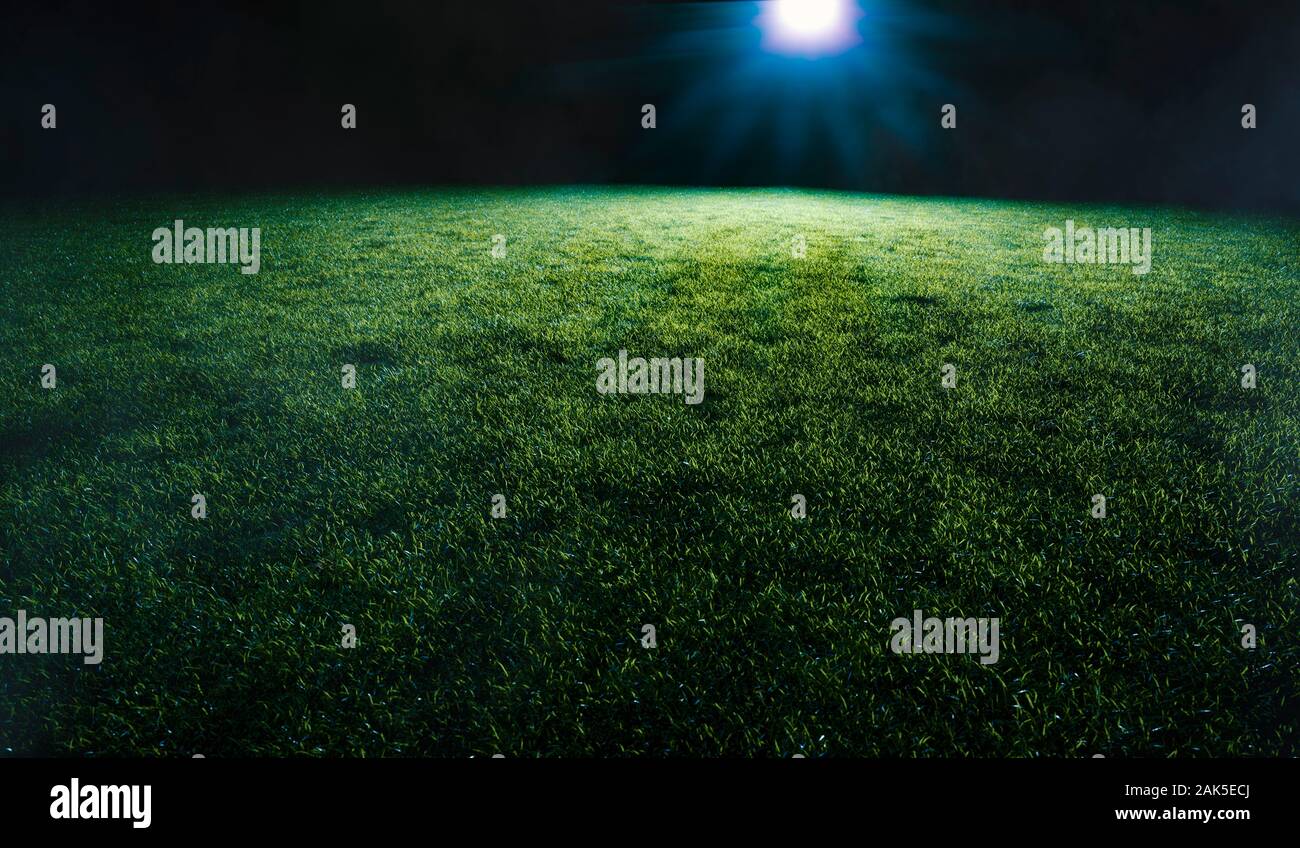 Spotlight shining on the green turf of an empty sports field at night ...