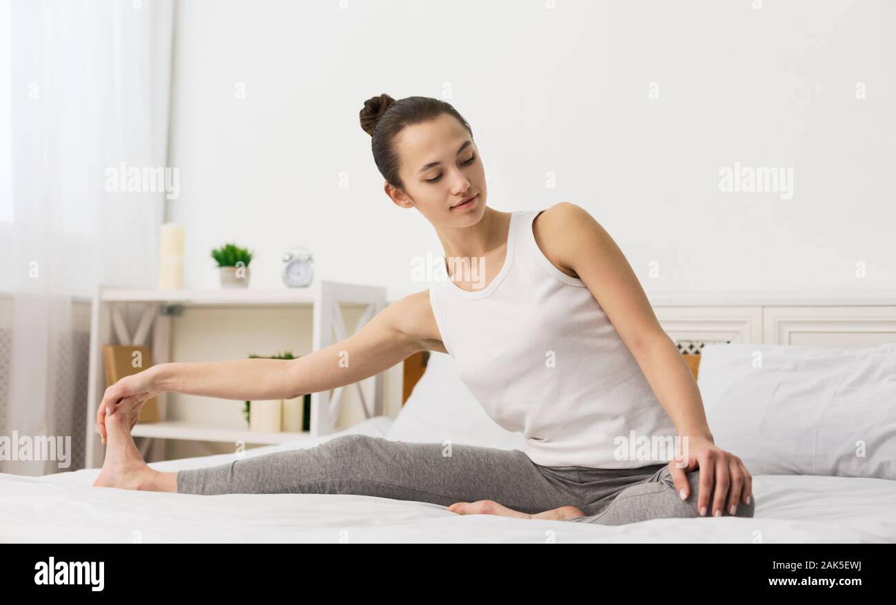 Healthy and sport lifestyle. Woman doing morning workout on bed ...