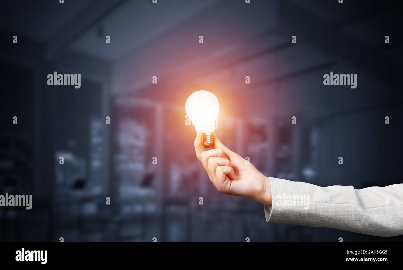 Human hand with glowing incandescent lamp Stock Photo - Alamy