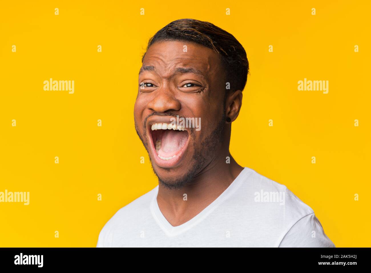 No. Emotional Afro Man Screaming Loudly Standing Over Yellow Background ...