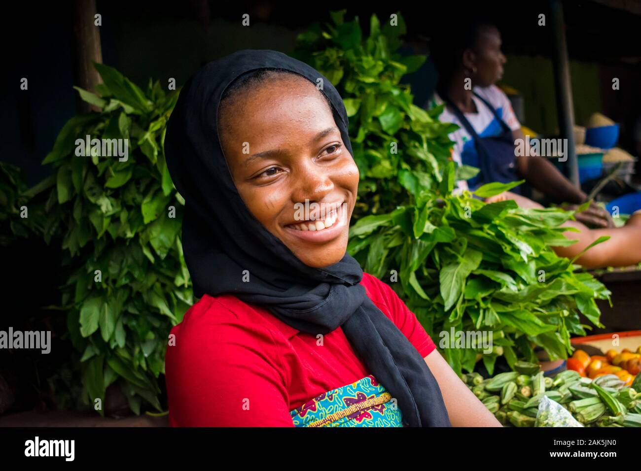 young happy african woman selling in a local market laughing Stock ...