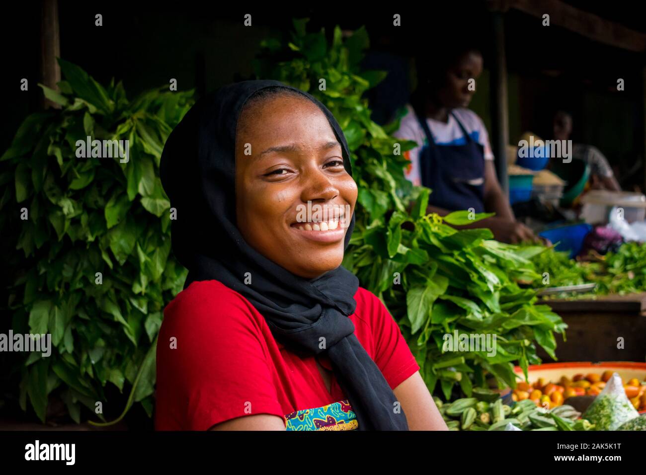 young happy african woman selling in a local market laughing Stock ...