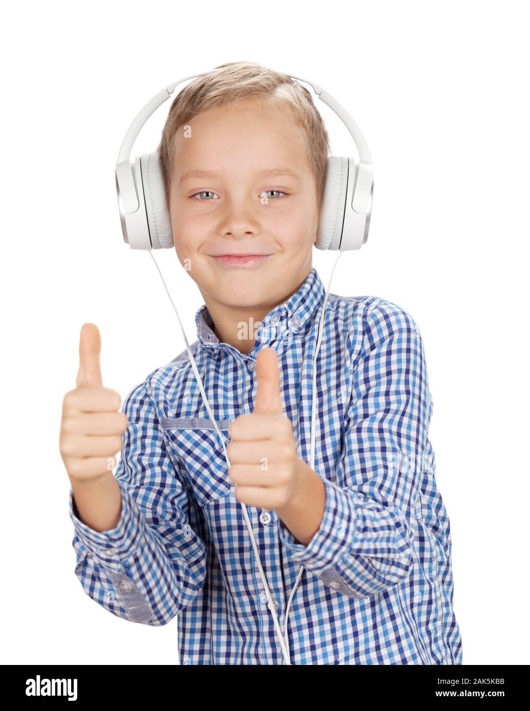 Young boy listening to music with headphones and making thumbs up ...
