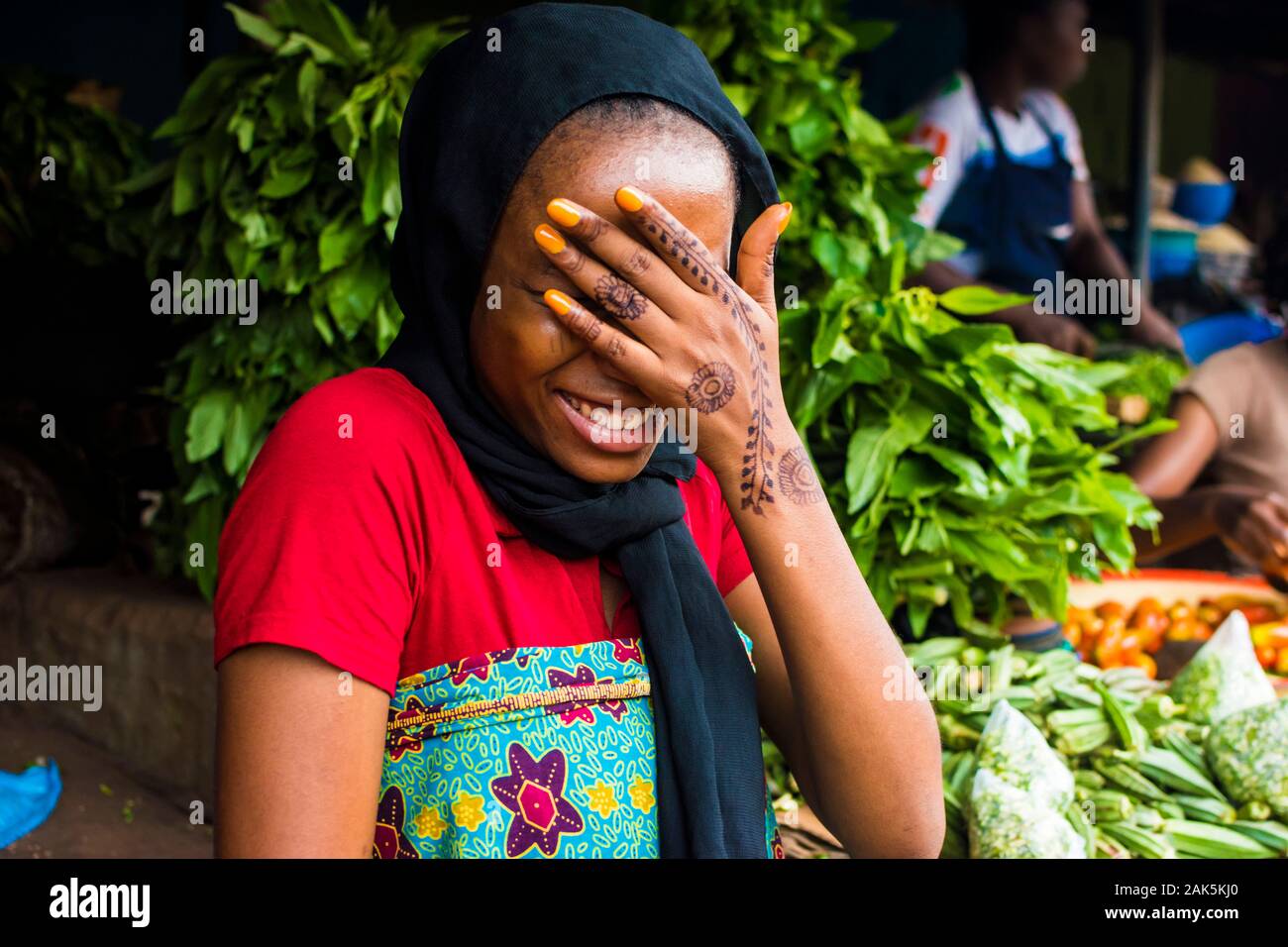 young happy african woman selling in a local market laughing Stock ...