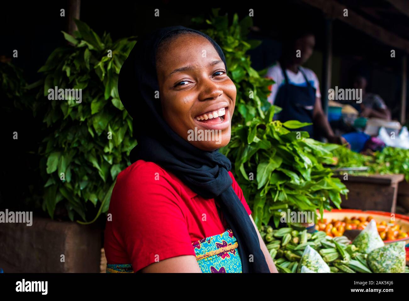 young happy african woman selling in a local market laughing Stock ...