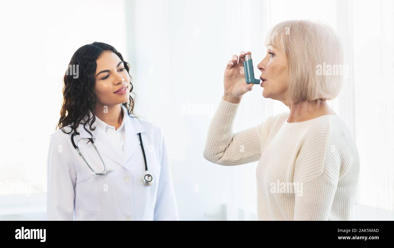 Medical Advice. Elderly woman using asthma inhaler, mexican doctor ...
