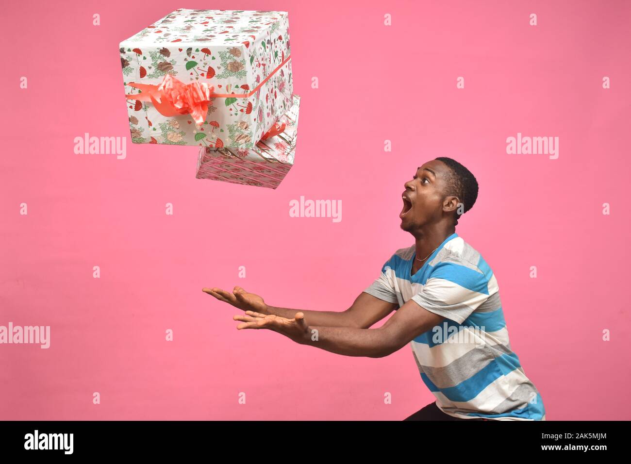 young black man feeling excited while catching gift boxes Stock Photo ...