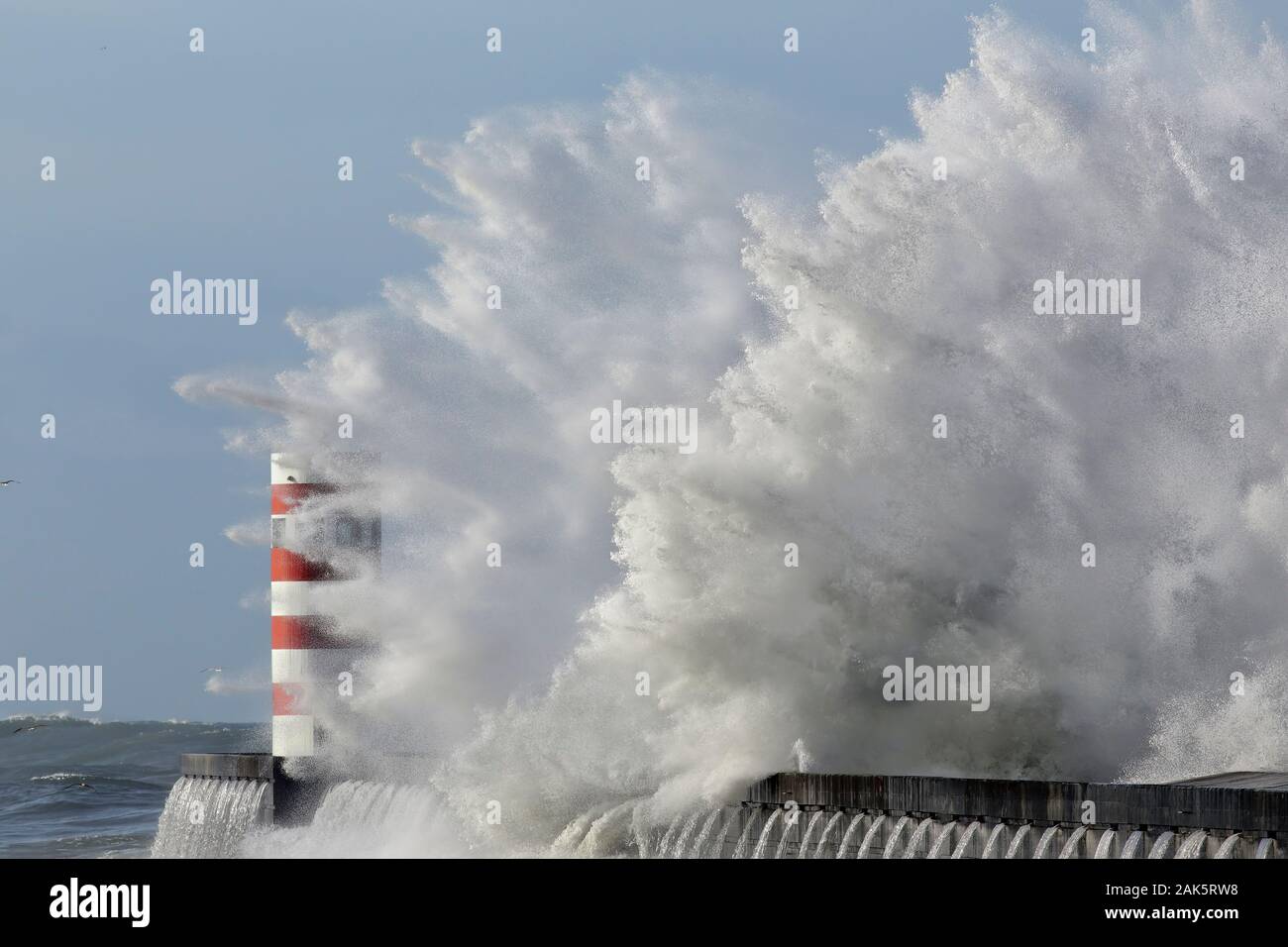 Big wave splash against pier and beacon Stock Photo - Alamy