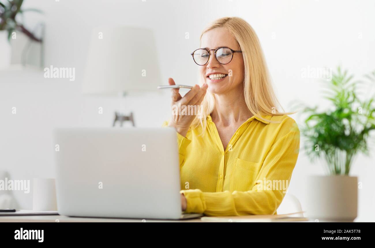 Mature woman recording audio message hi-res stock photography and ...
