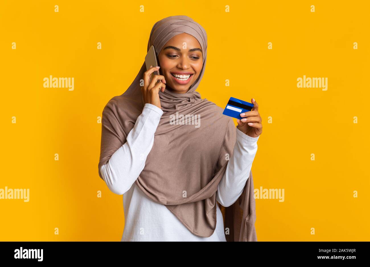 Customer service concept. Young black muslim woman in hijab holding ...