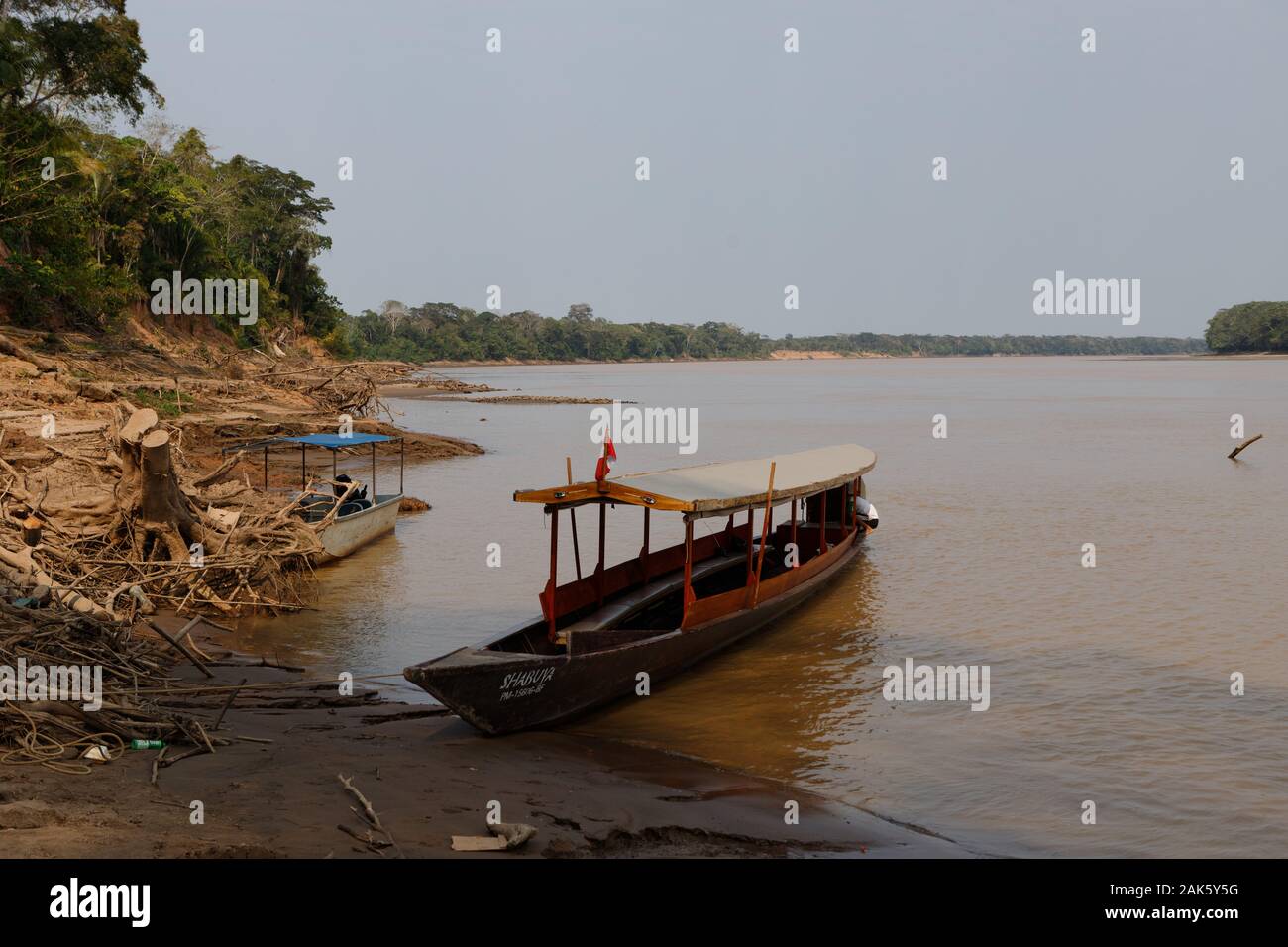 Typical jungle boat on the banks of the Amazonas river with jungle ...
